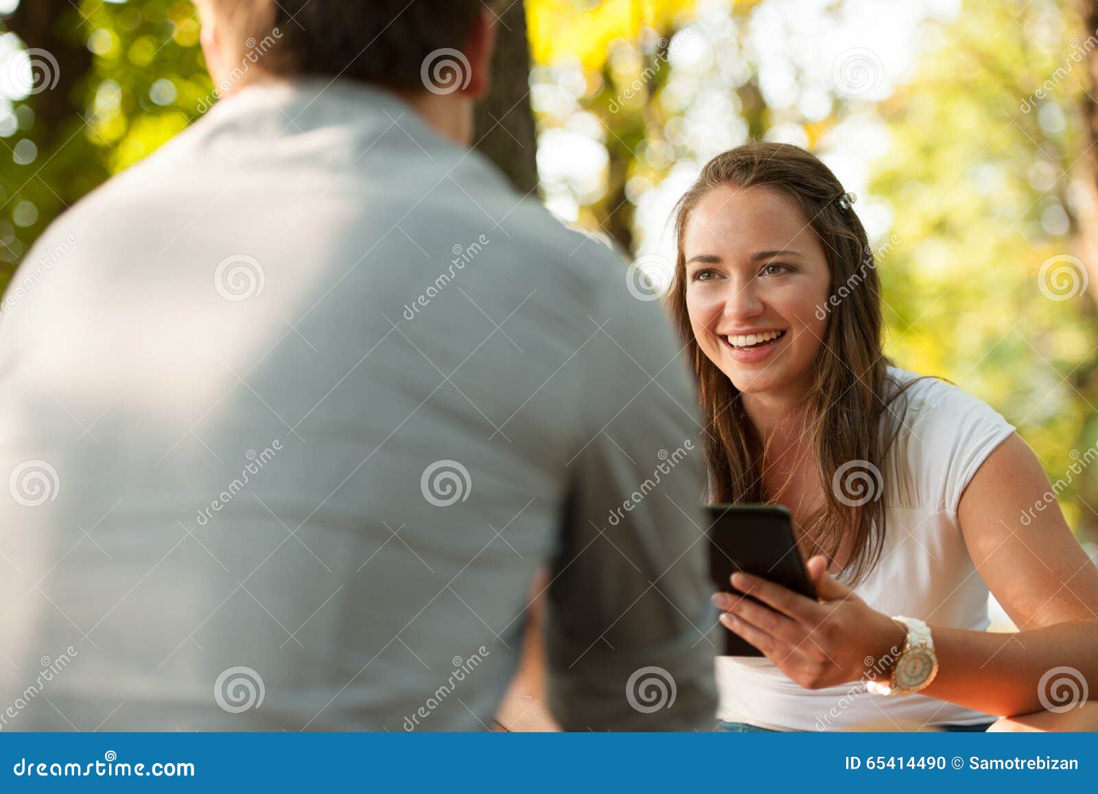 Young Couple Having Fun on a Bench in Park while Socializing Over Web ...