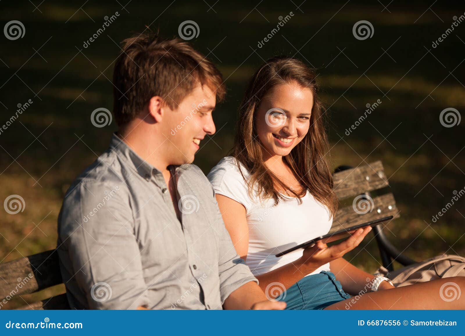 Young Couple Having Fun on a Bench in Park while Socializing Over Web ...