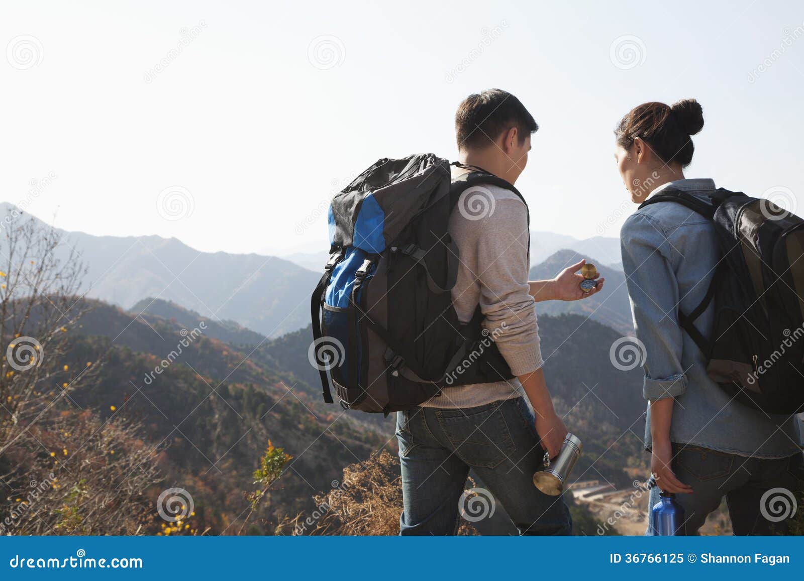 Young Couple Hiking and Looking at the Compass Stock Image - Image of ...
