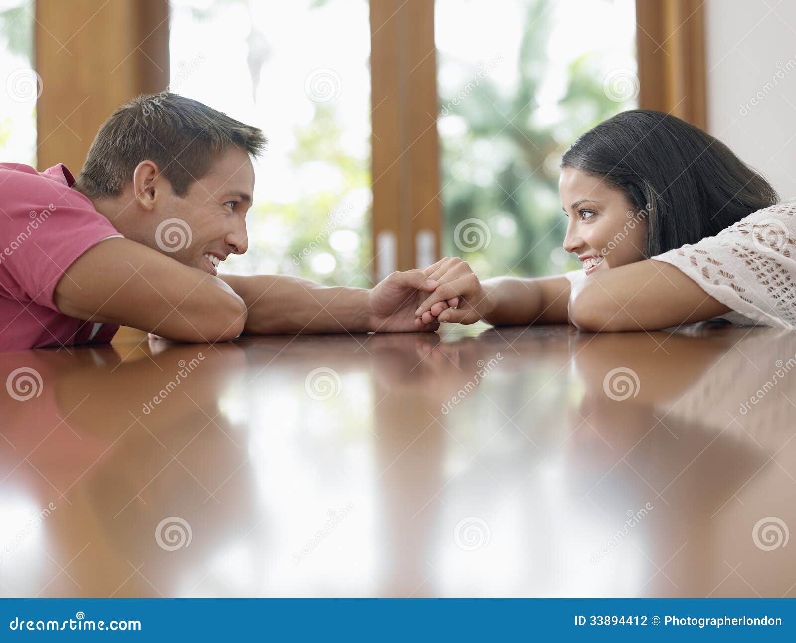 Young Couple Holding Hands on Table Stock Photo - Image of house ...