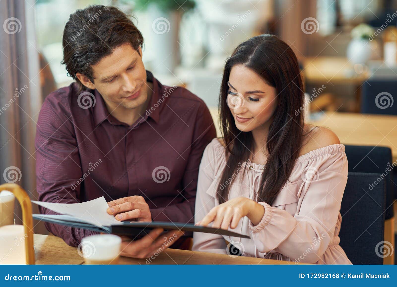 Young Couple Looking at Menu in Cafe Stock Photo - Image of beautiful ...
