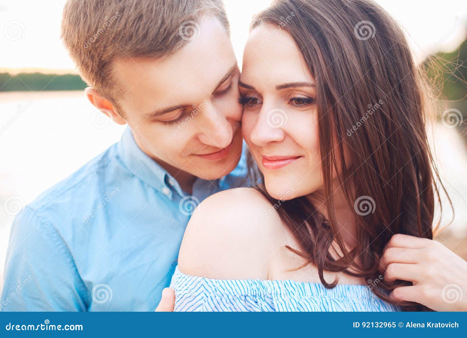 Young Couple In Love Hug Each Other At The Lake Outdoor In Summer Day