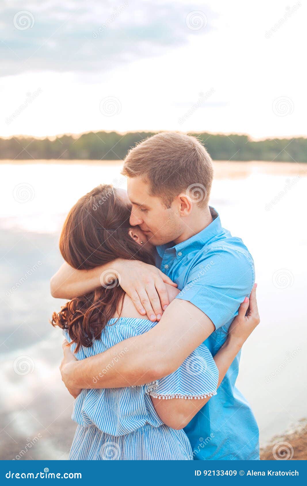 Young Couple In Love Hug Each Other At The Lake Outdoor In Summer Day