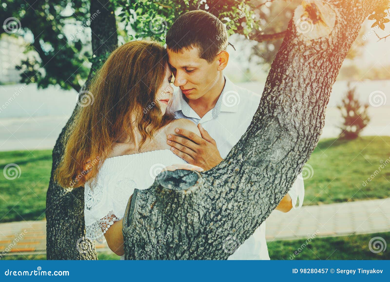 Young Couple In Love Hug Each Other In Summer Park Enjoying Together