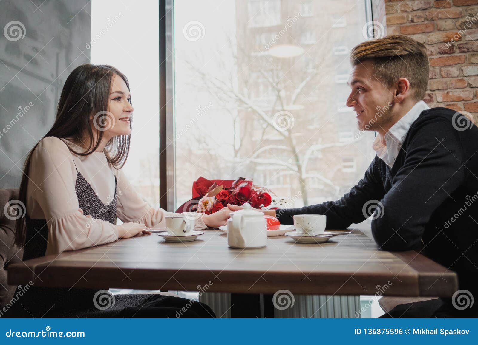 Young Couple In Love Man And Woman Sit At A Table In A Cafe St
