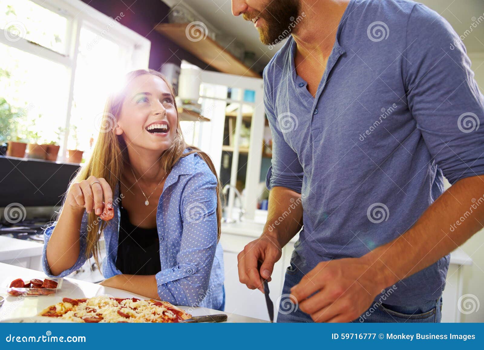 Young Couple Making Pizza in Kitchen Together Stock Image - Image of ...