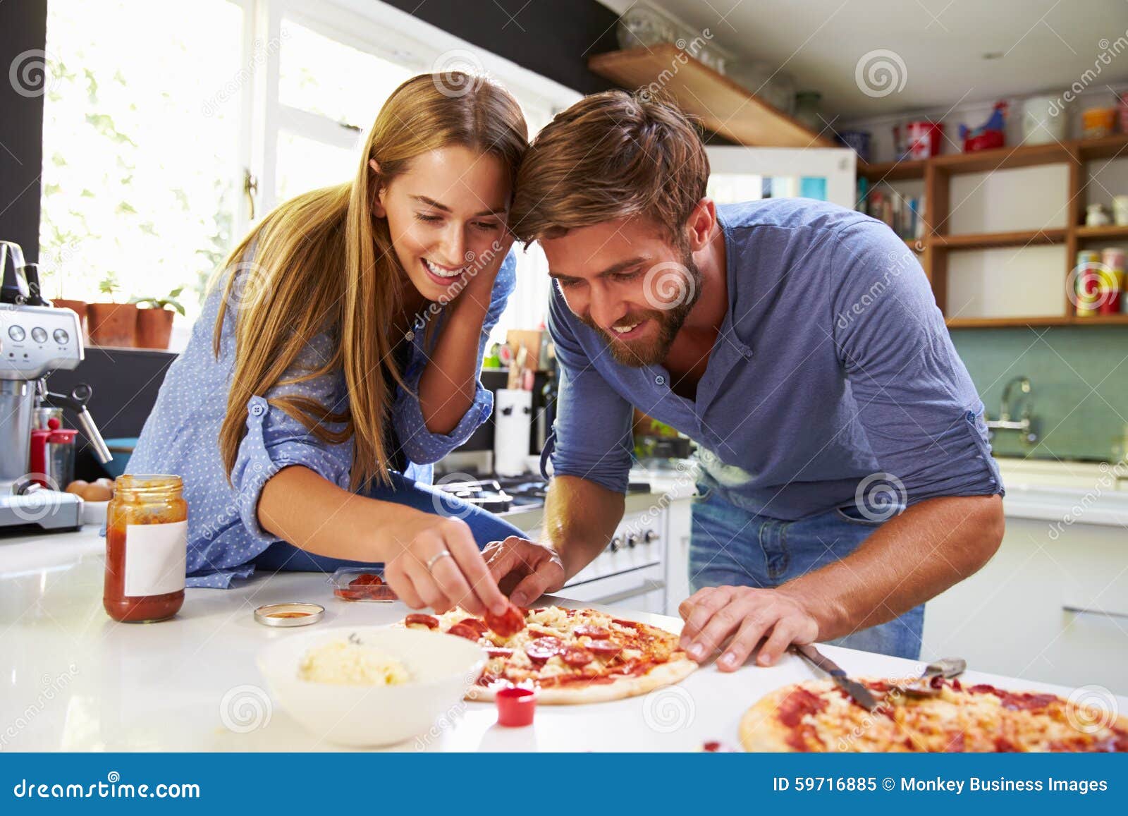 Young Couple Making Pizza in Kitchen Together Stock Image - Image of ...