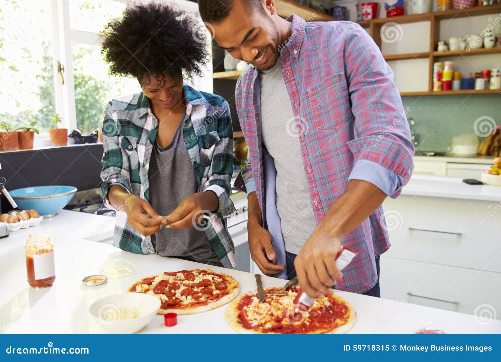 Young Couple Making Pizza in Kitchen Together Stock Image - Image of ...