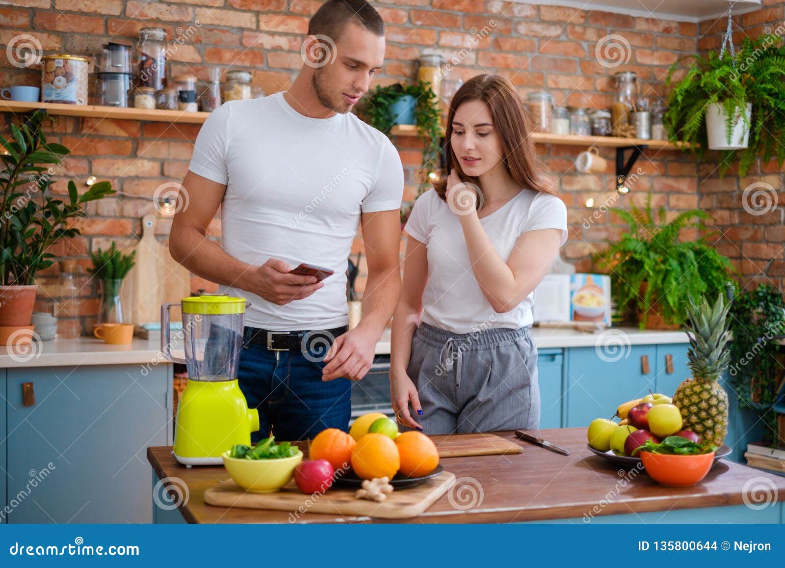 Young Couple Making Smoothie in Kitchen Stock Photo - Image of juice ...