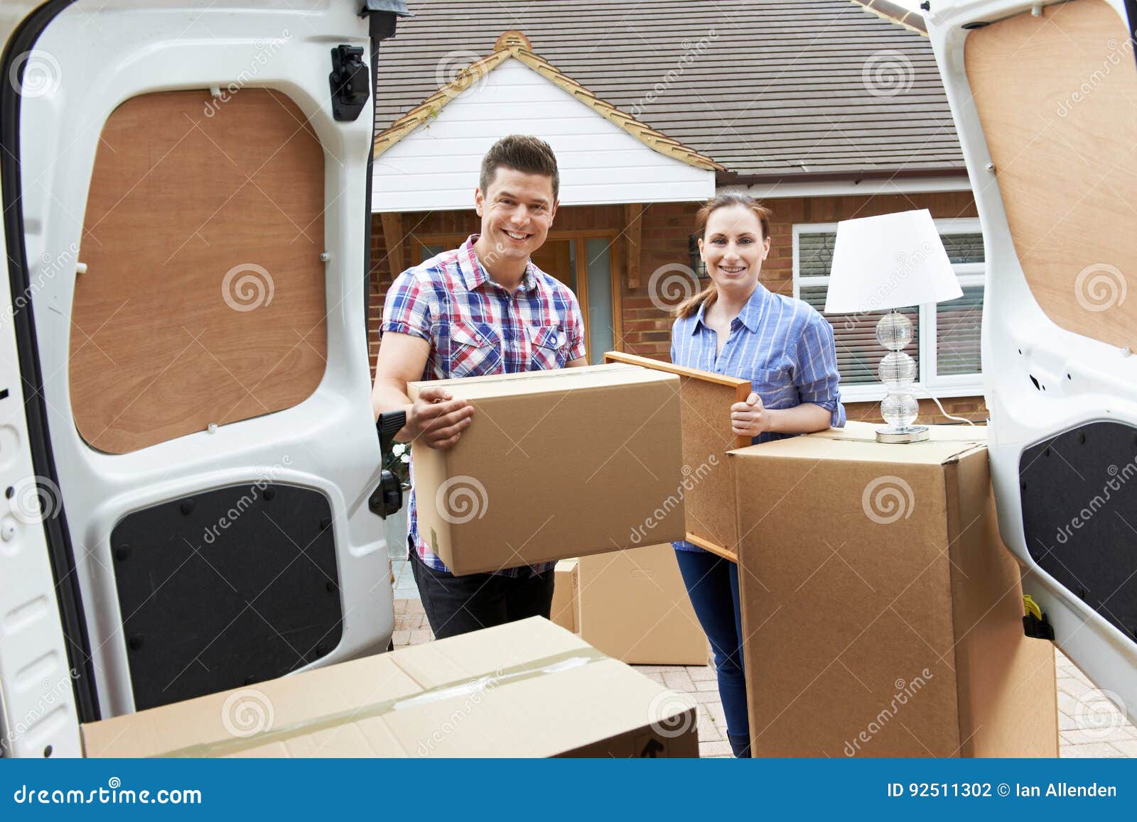 Young Couple Moving in To New Home Unloading Removal Van Stock Photo ...