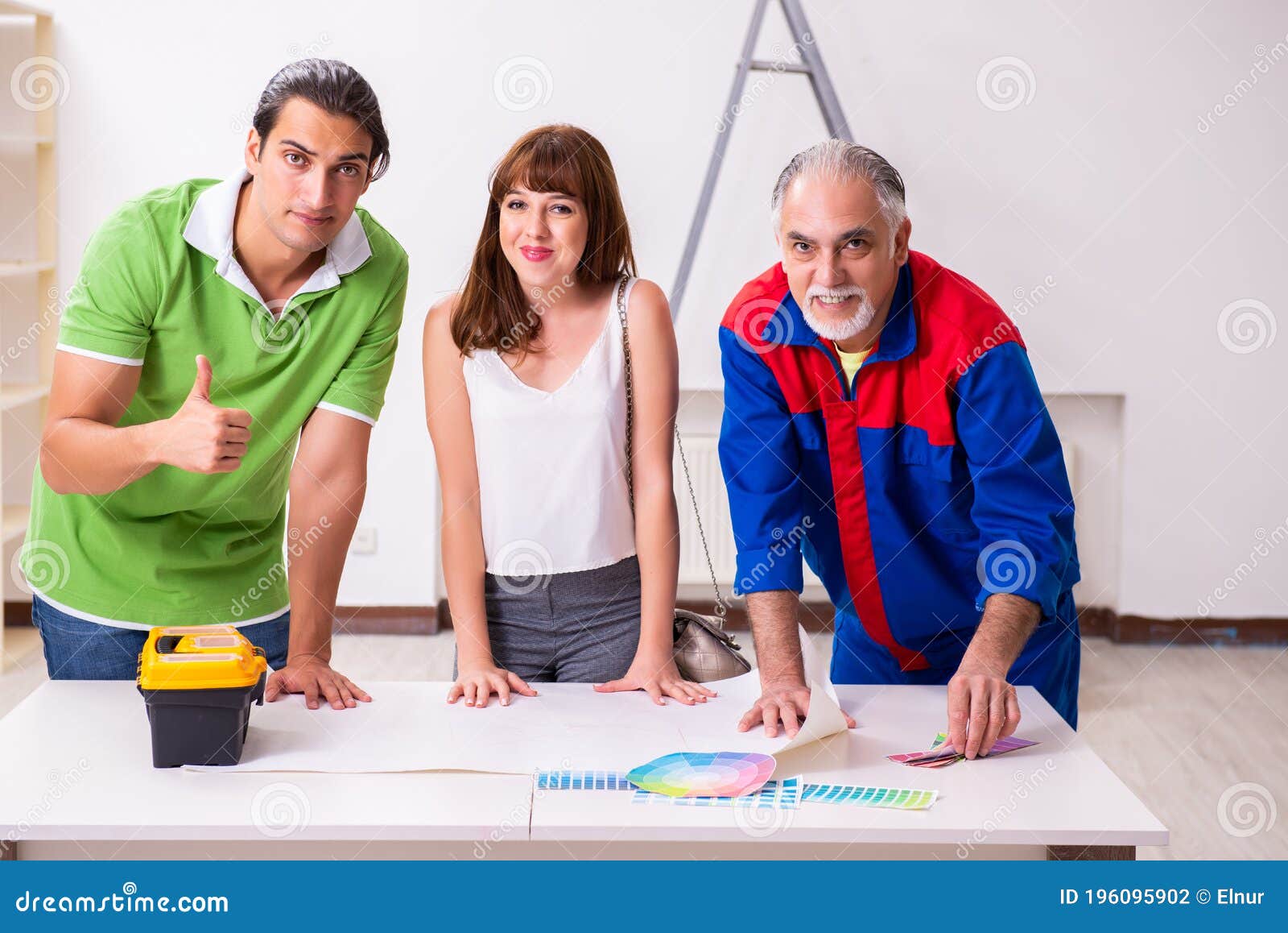 Young Couple and Old Contractor in Home Renovation Concept Stock Photo ...