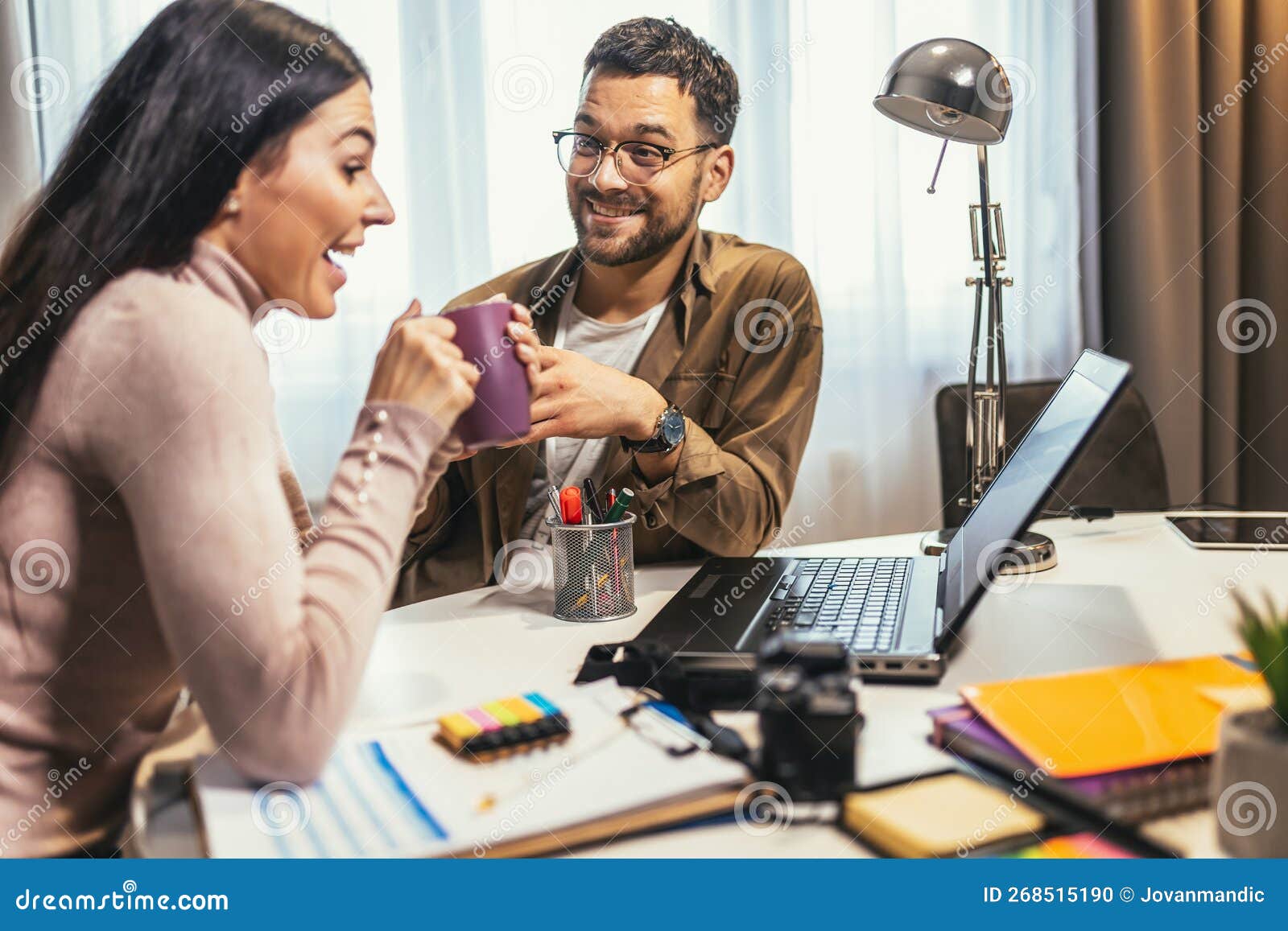 Couple of Photographers Working with Laptop at the Working Place with ...