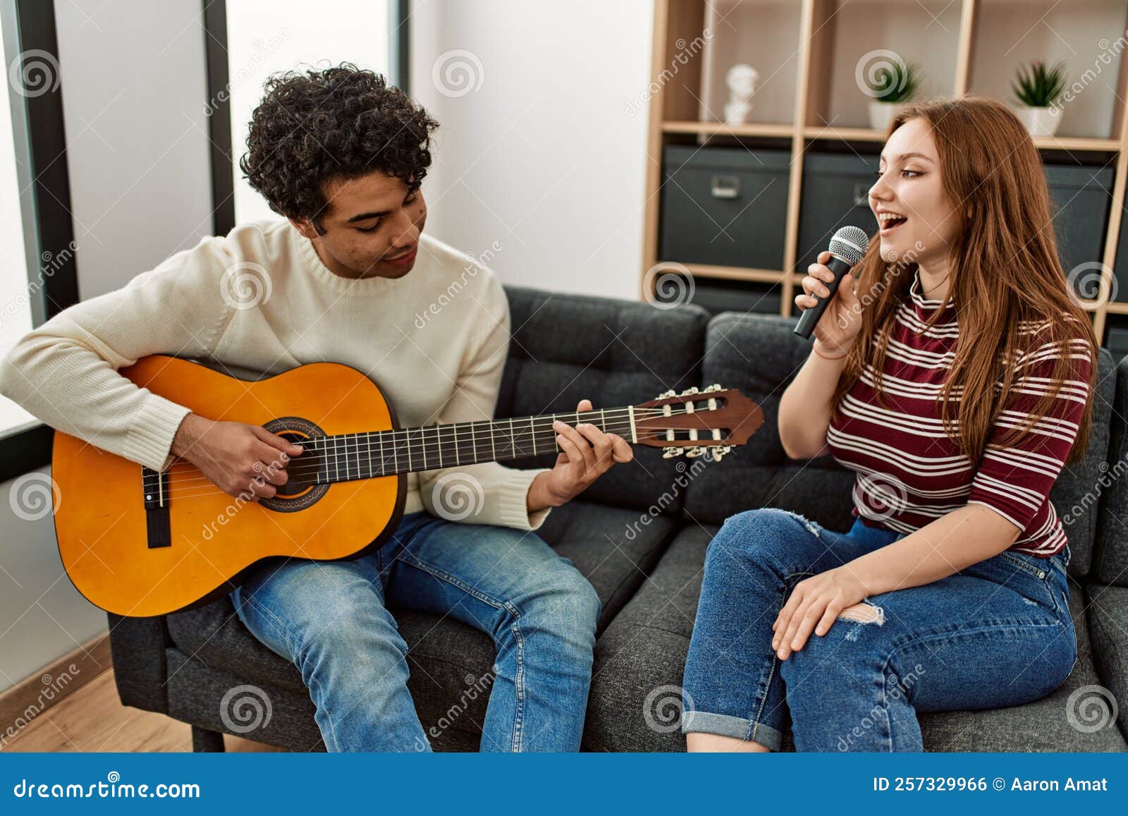 Young Couple Playing Classical Guitar and Singing Using Microphone at ...