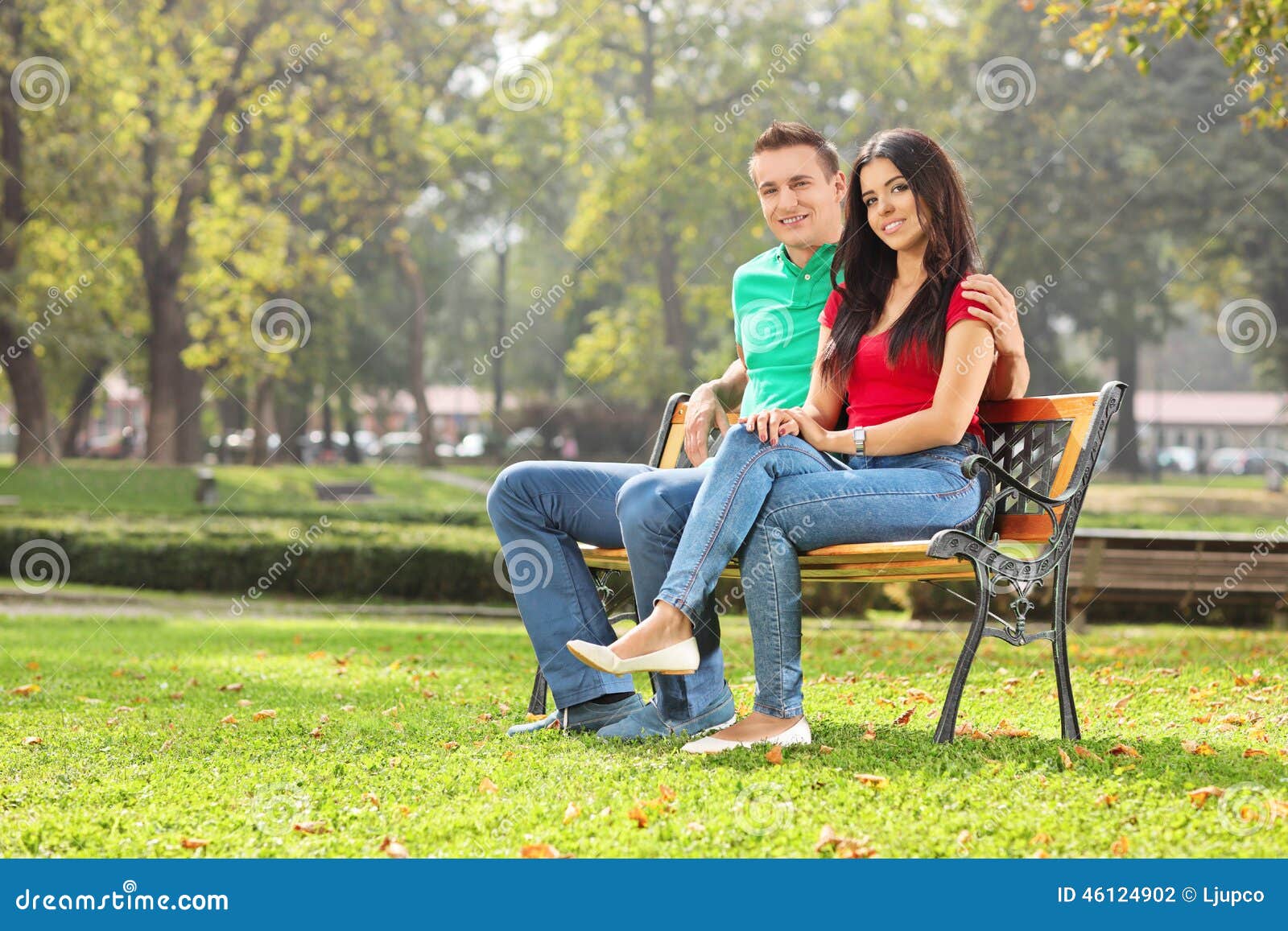 Young Couple Posing Seated on a Bench in Park Stock Photo - Image of ...