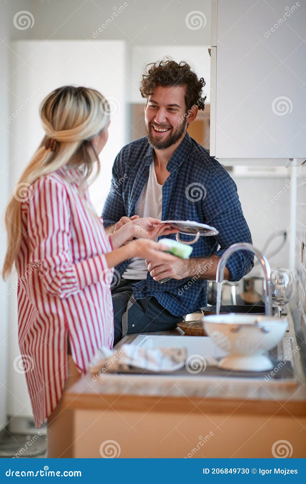A Young Couple Sharing Housework in the Kitchen. Kitchen, Housework ...