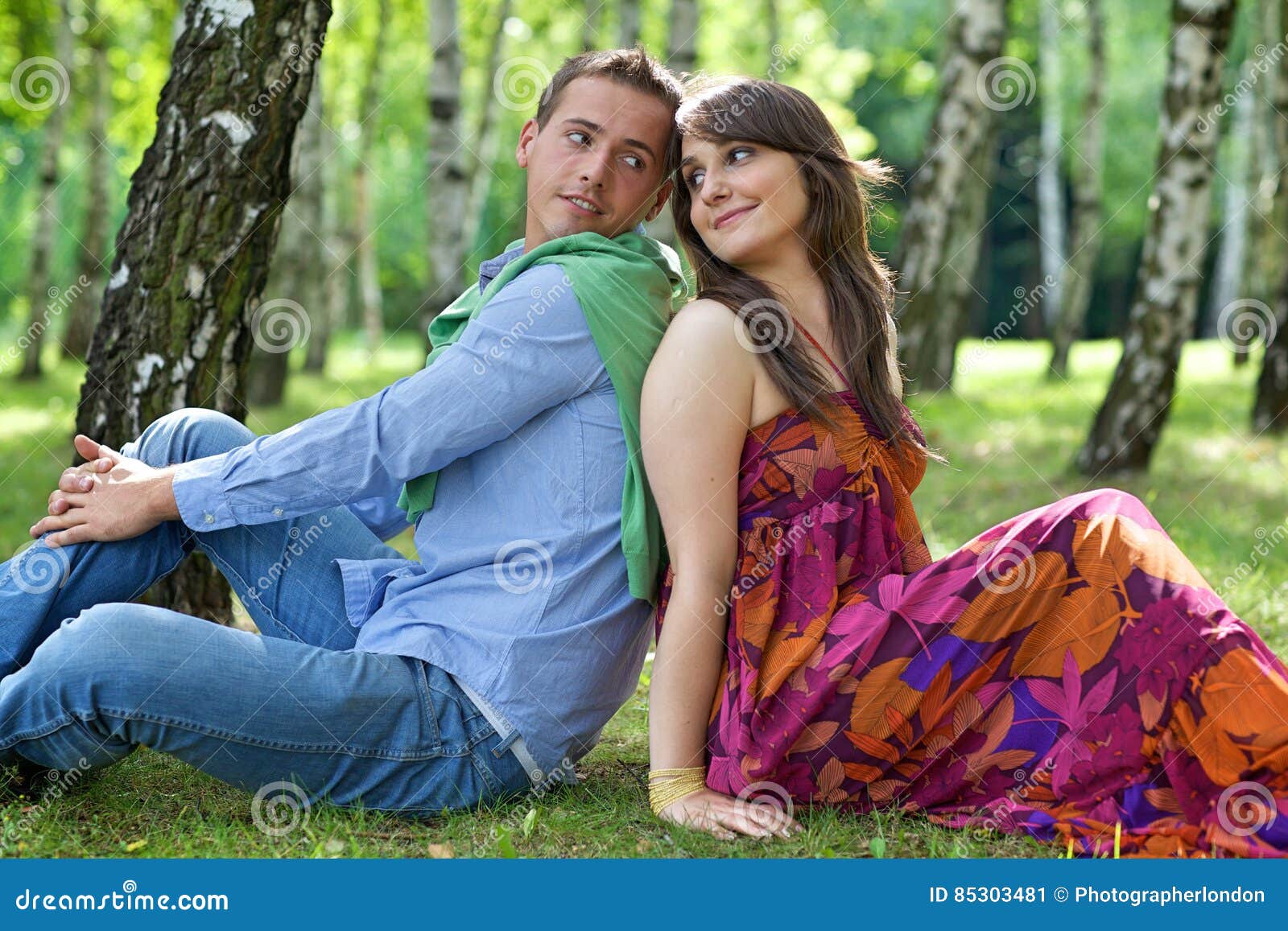 Young Couple Sitting Back To Back in Park Stock Image - Image of ...