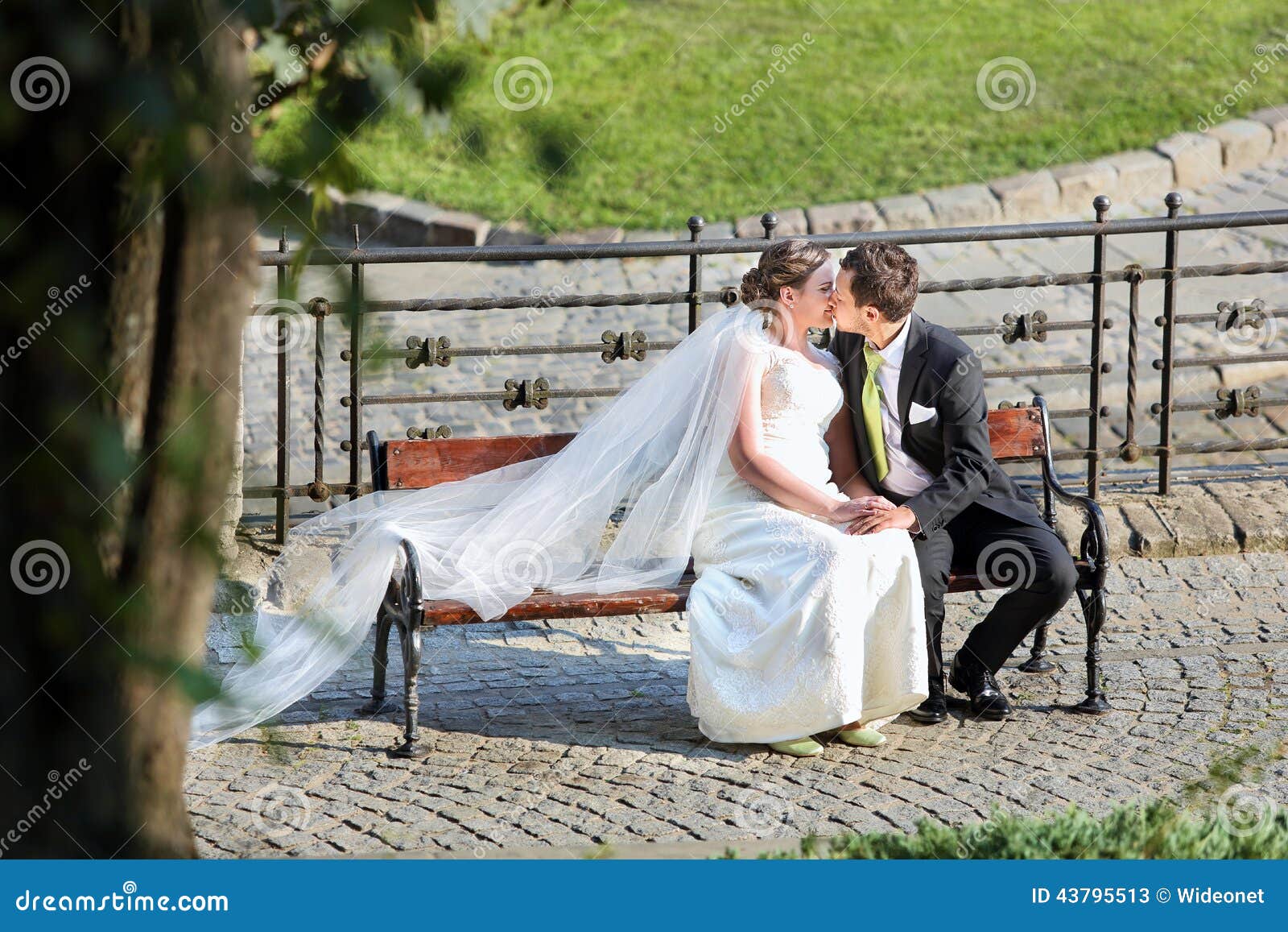 Young Couple Sitting on a Bench and Kissing in a Hug Stock Image ...
