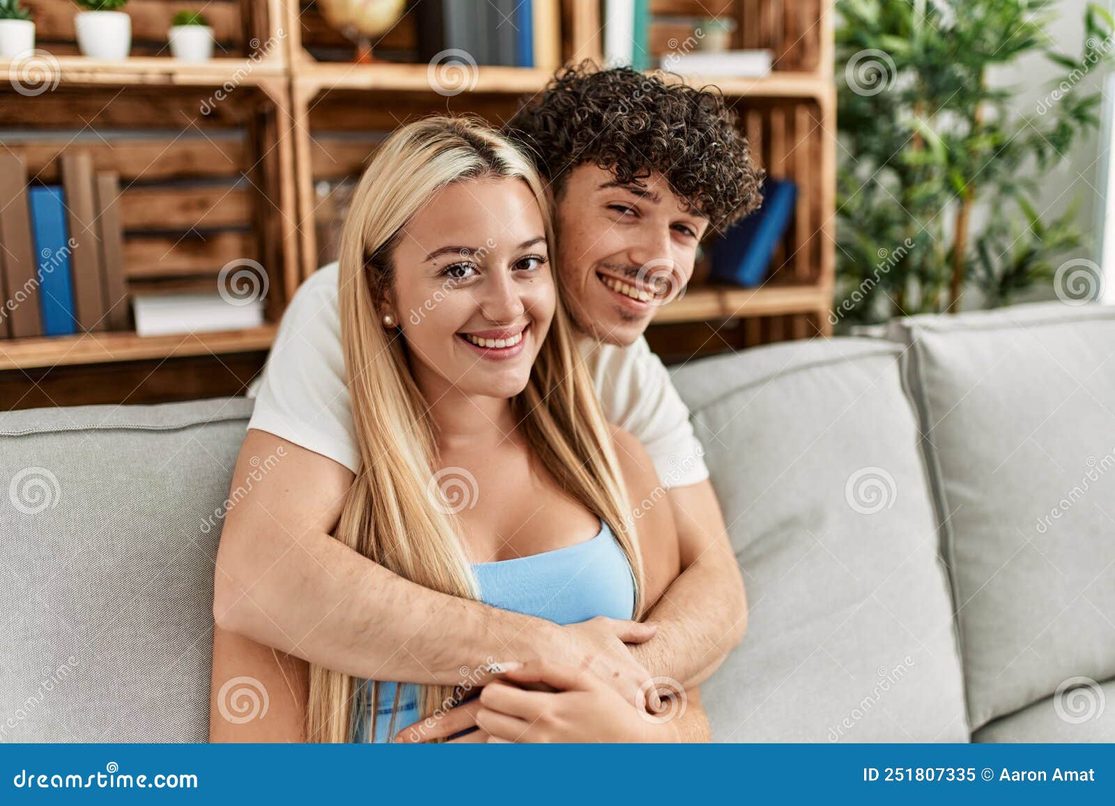 Young Couple Sitting on the Sofa Hugging at Home Stock Image - Image of ...