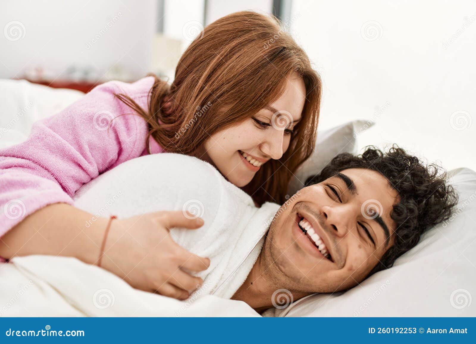 Young Couple Smiling Happy and Hugging Lying on the Bed at Bedroom ...