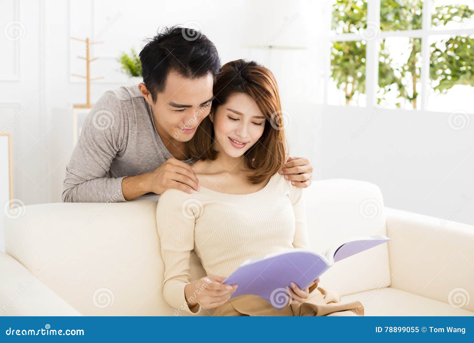 Young Couple Spending Time Reading Together on Sofa Stock Image - Image ...