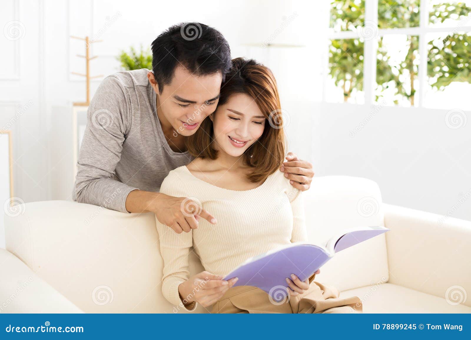 Young Couple Spending Time Reading Together on Sofa Stock Image - Image ...