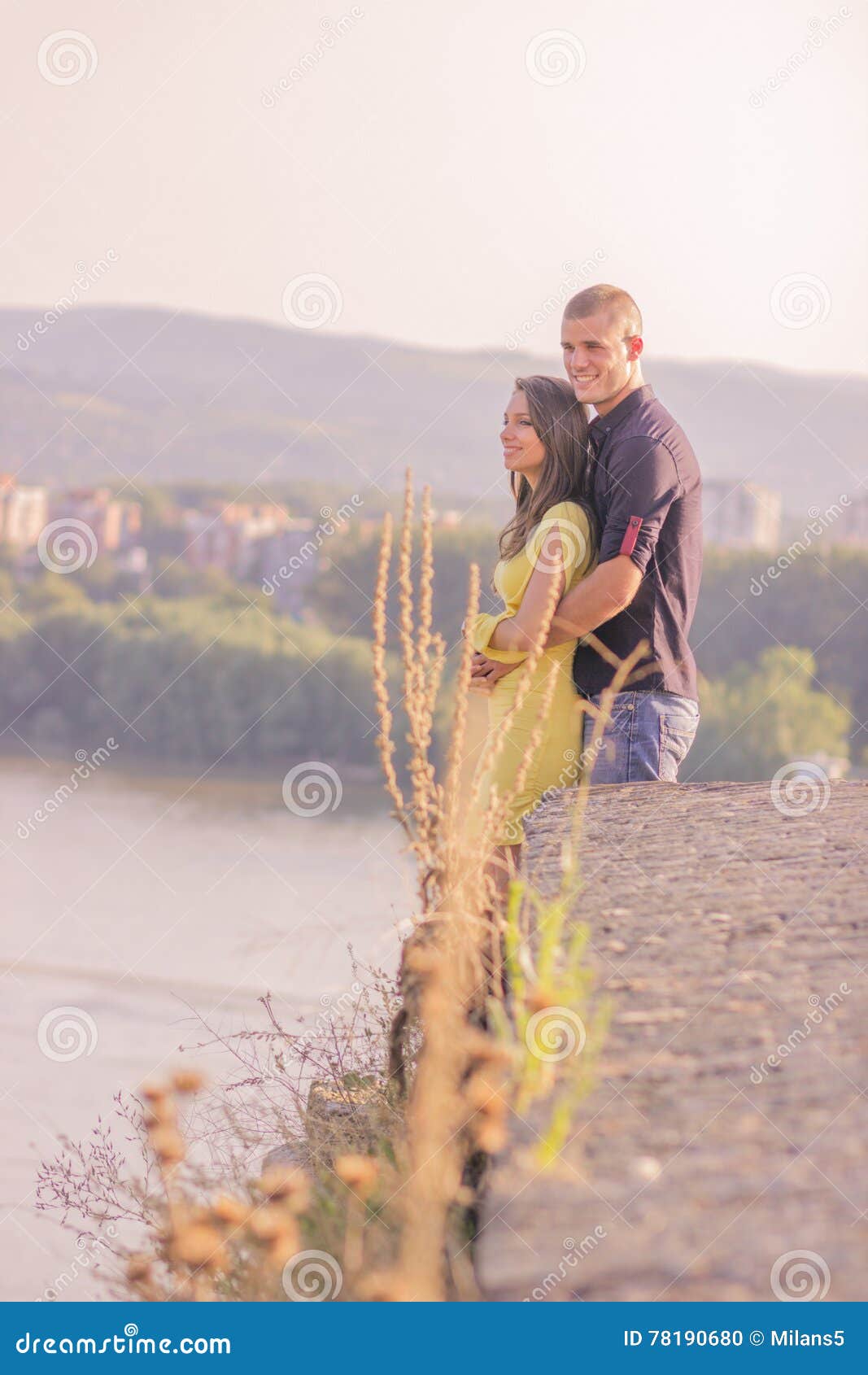 Young Couple Standing Hugging on Cliff High Above Stock Photo - Image ...