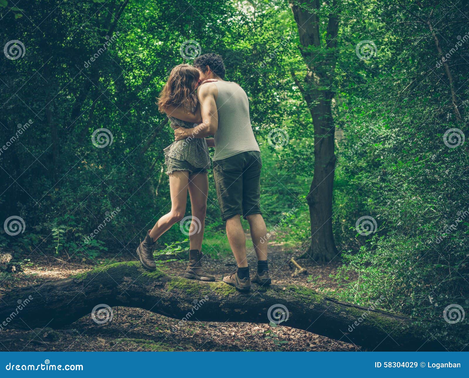 Young Couple Standing on Log Kissing Stock Image - Image of couple ...