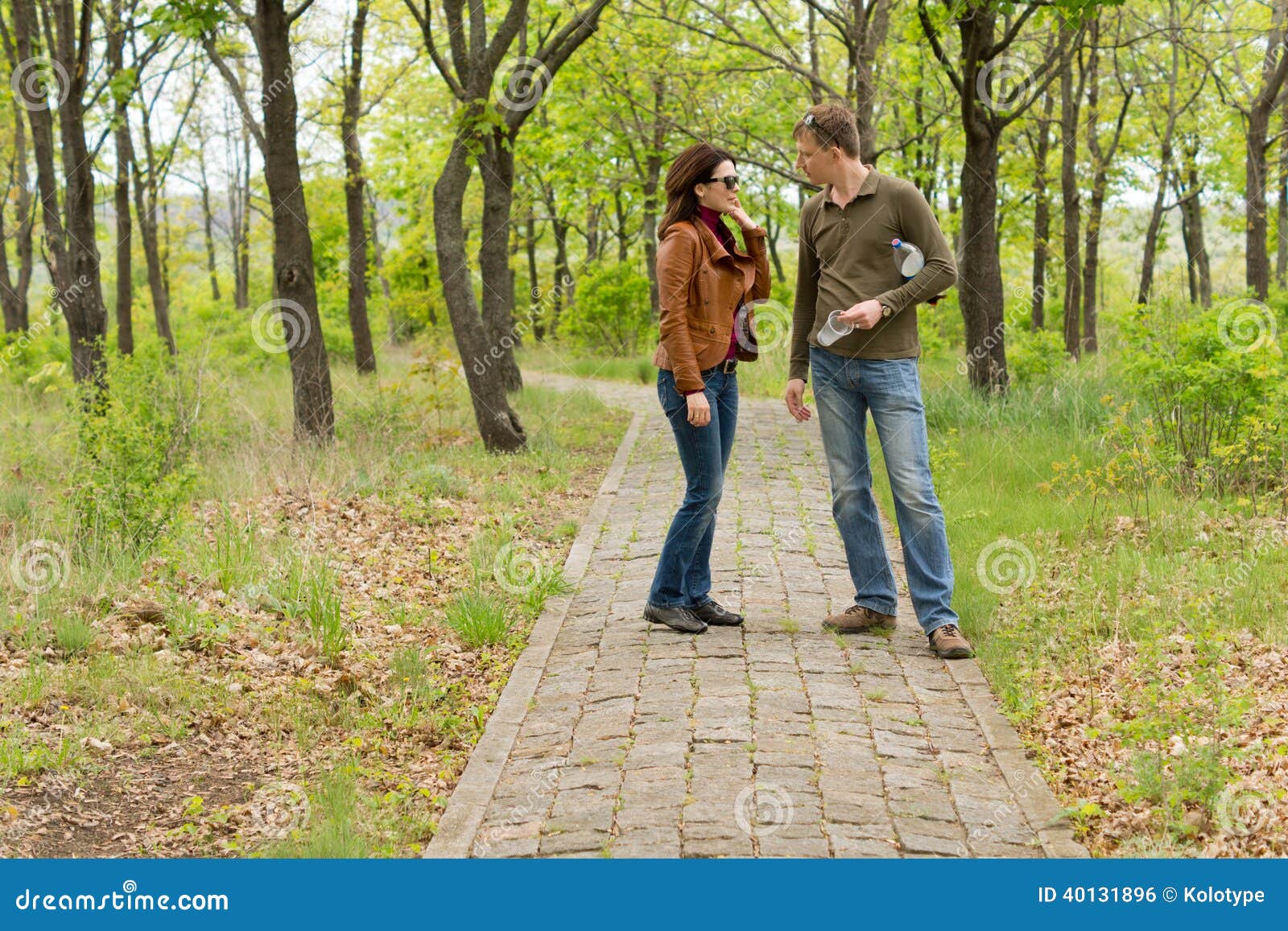 Young Couple Standing Talking in a Park Stock Photo - Image of ...