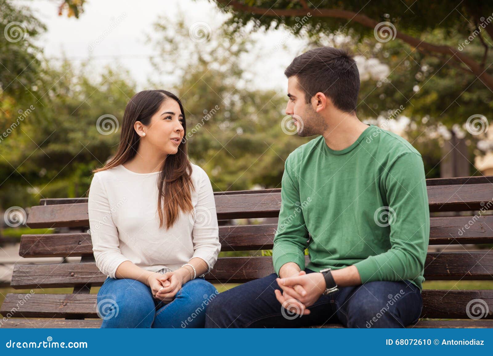 Young Couple Talking at a Park Stock Photo - Image of casual, outdoor ...