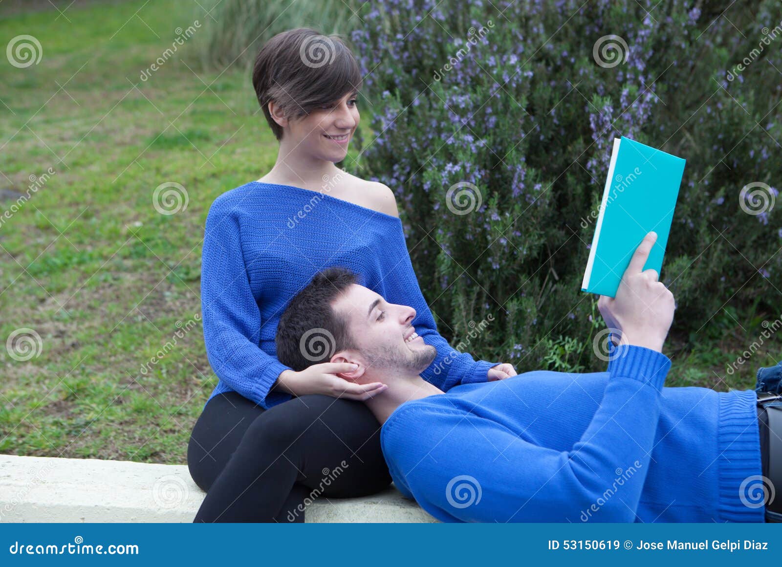 Young Couple Together Reading A Book Together In The Park Stock Image
