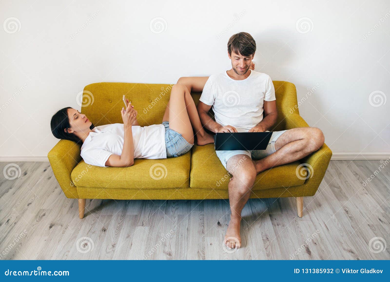 Young Couple Using Gadgets while Relaxing at Home Stock Photo - Image ...