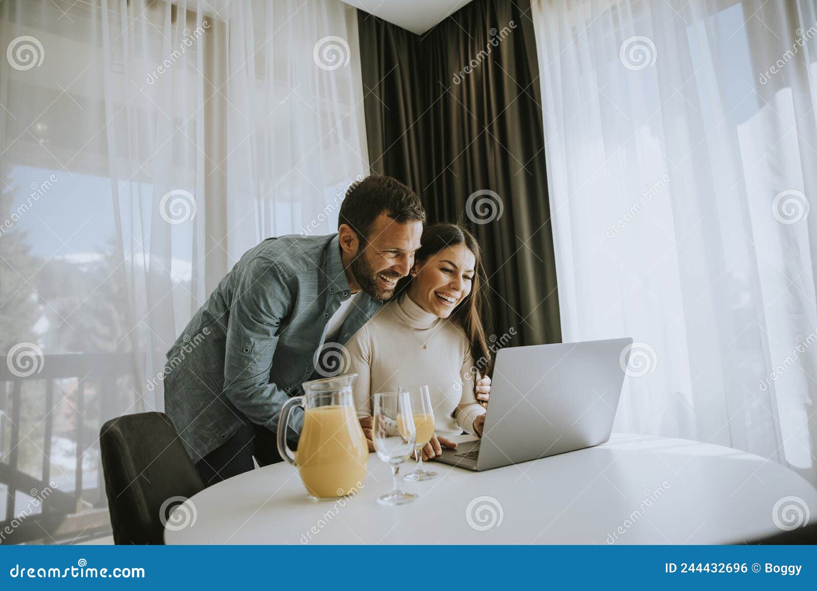 Young Couple Using Laptop Computer on the Table in the Living Room ...
