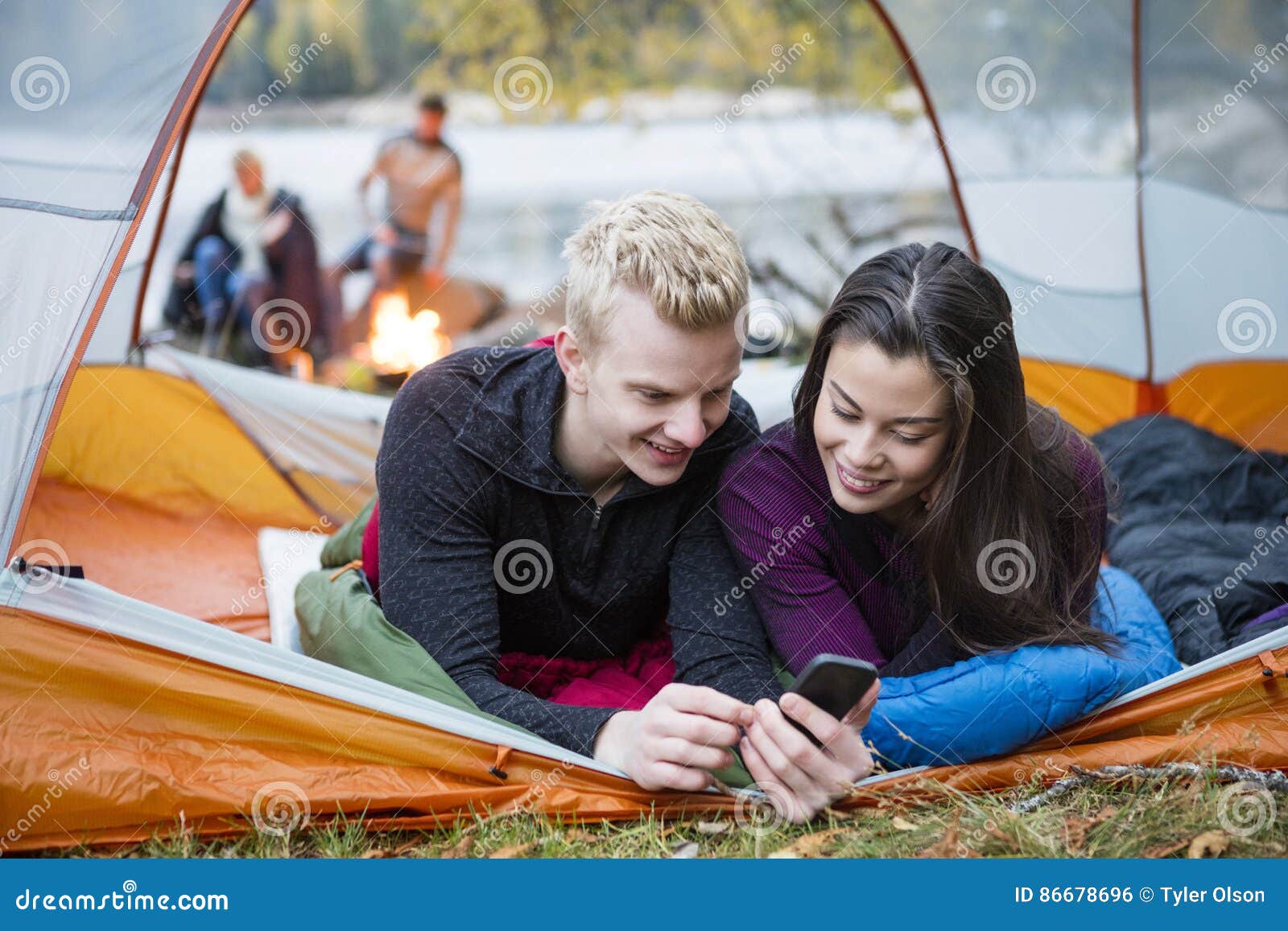 Young Couple Using Mobile Phone in Tent Stock Photo - Image of healthy ...