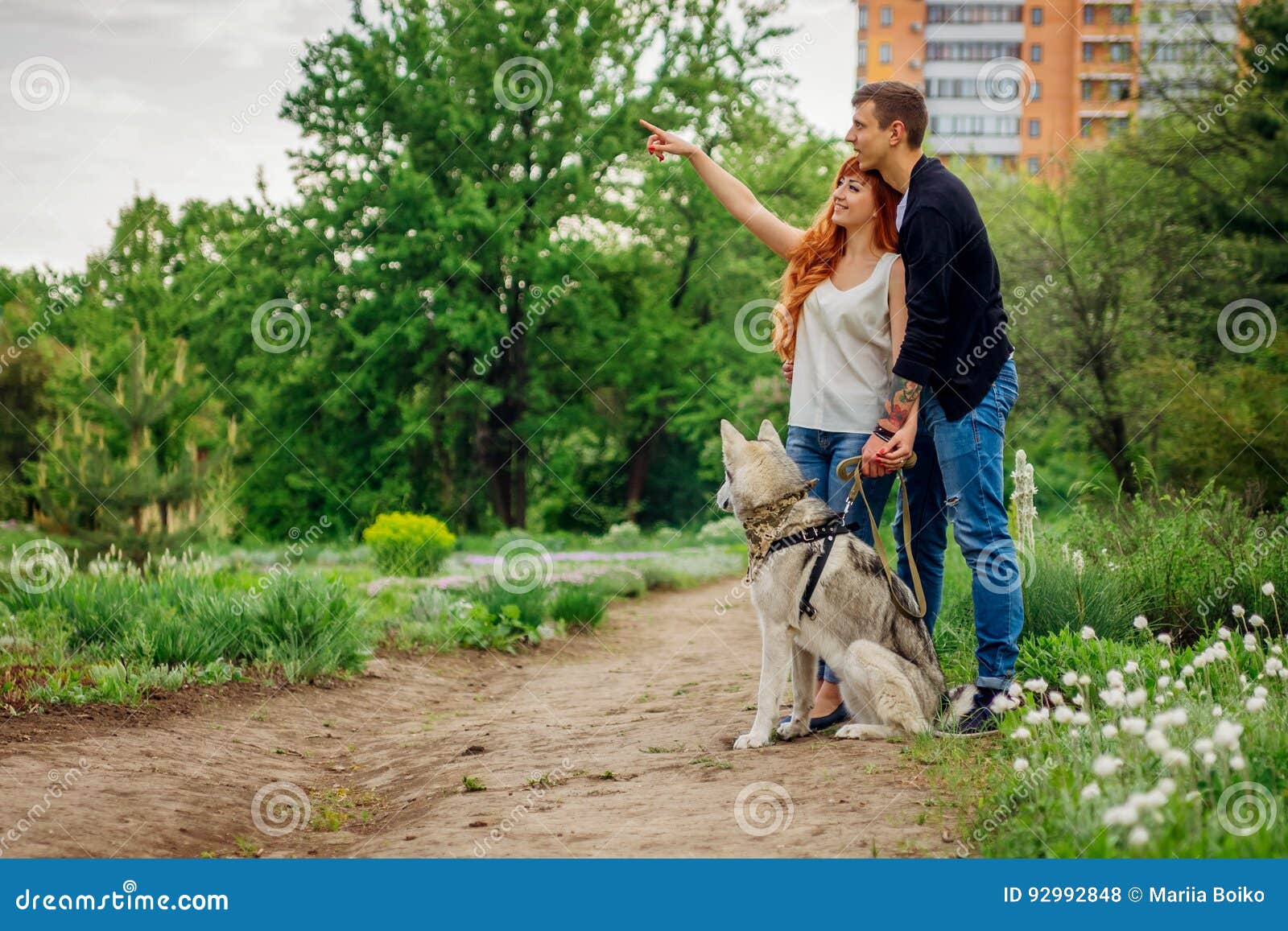 A Young Couple Walking a Dog in the Park Stock Photo - Image of female ...