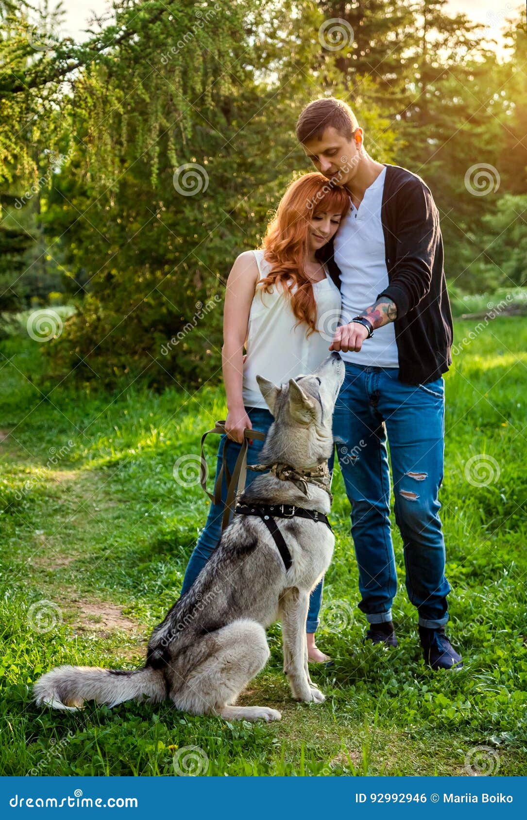 A Young Couple Walking a Dog in the Park Stock Photo - Image of ...