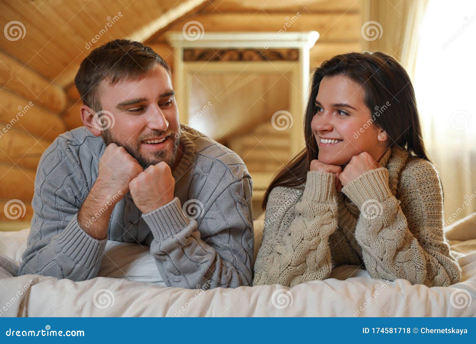 Young Couple Wearing Warm Sweaters on Bed at Home Stock Photo - Image ...