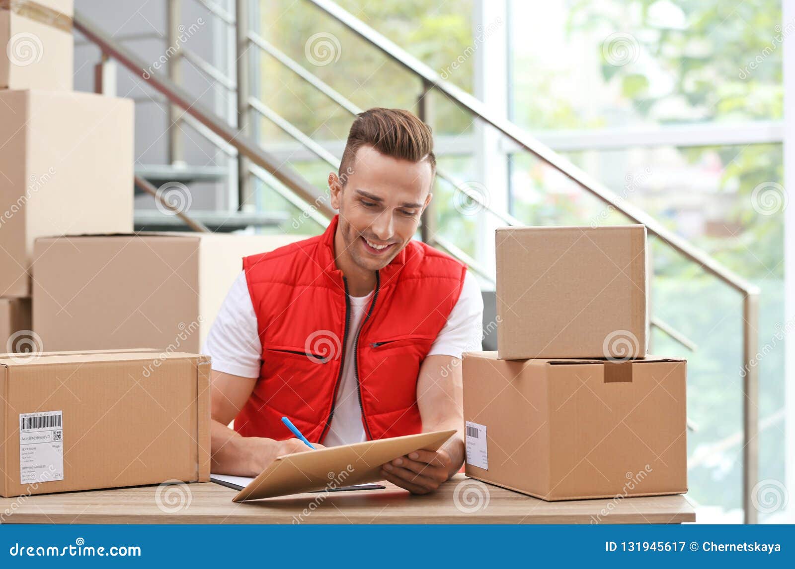 Young Courier Working with Papers among Parcels Stock Image - Image of ...