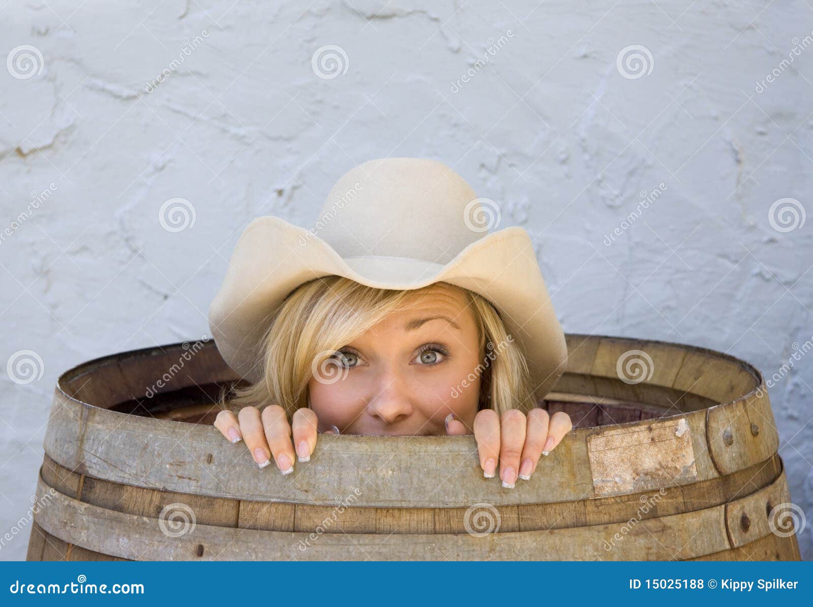 Young Cowgirl Smiling from Inside a Barrel Stock Photo - Image of blond ...