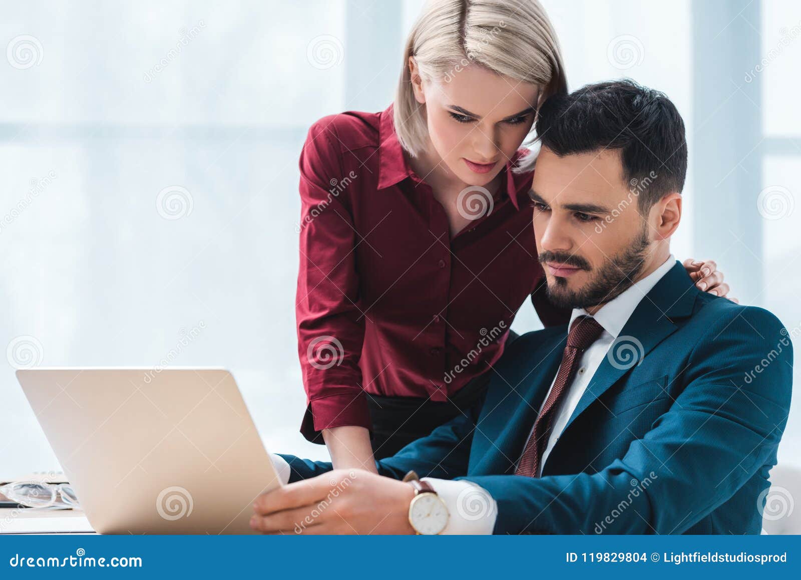 Young Coworkers Using Laptop and Flirting Stock Photo - Image of ...