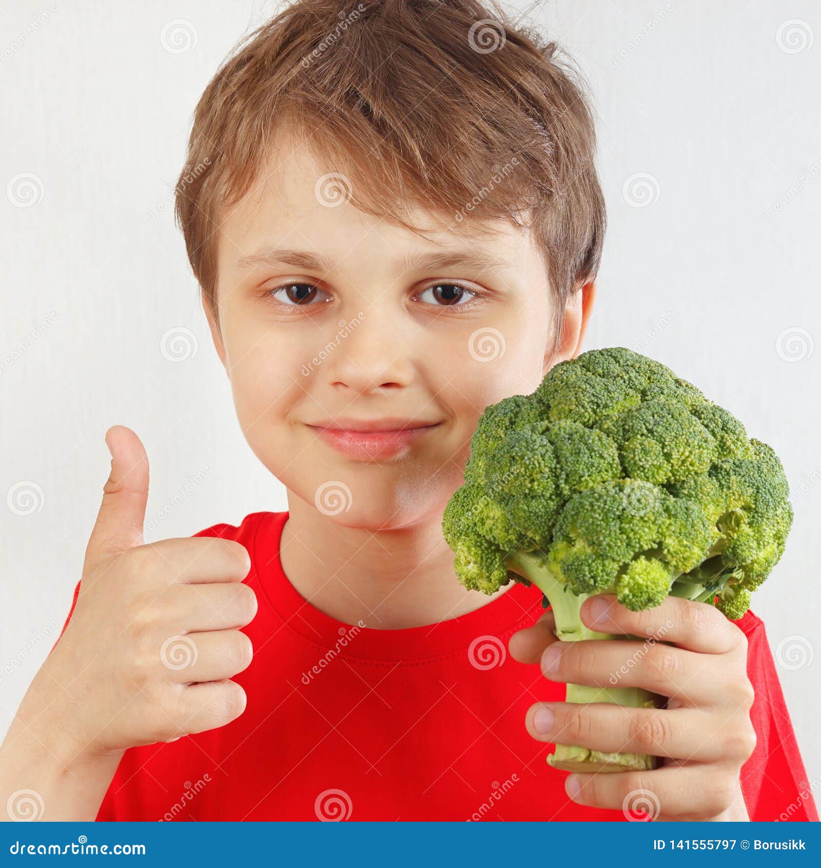 Young Cut Boy in a Red Shirt Recommends Broccoli on White Background ...