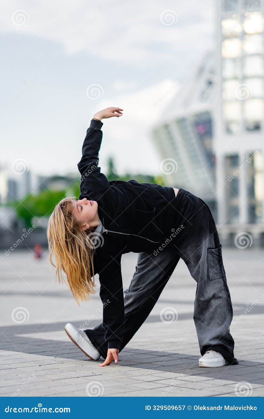 Young Dancer Performing Dynamic Move Outdoors in Modern Urban Setting ...