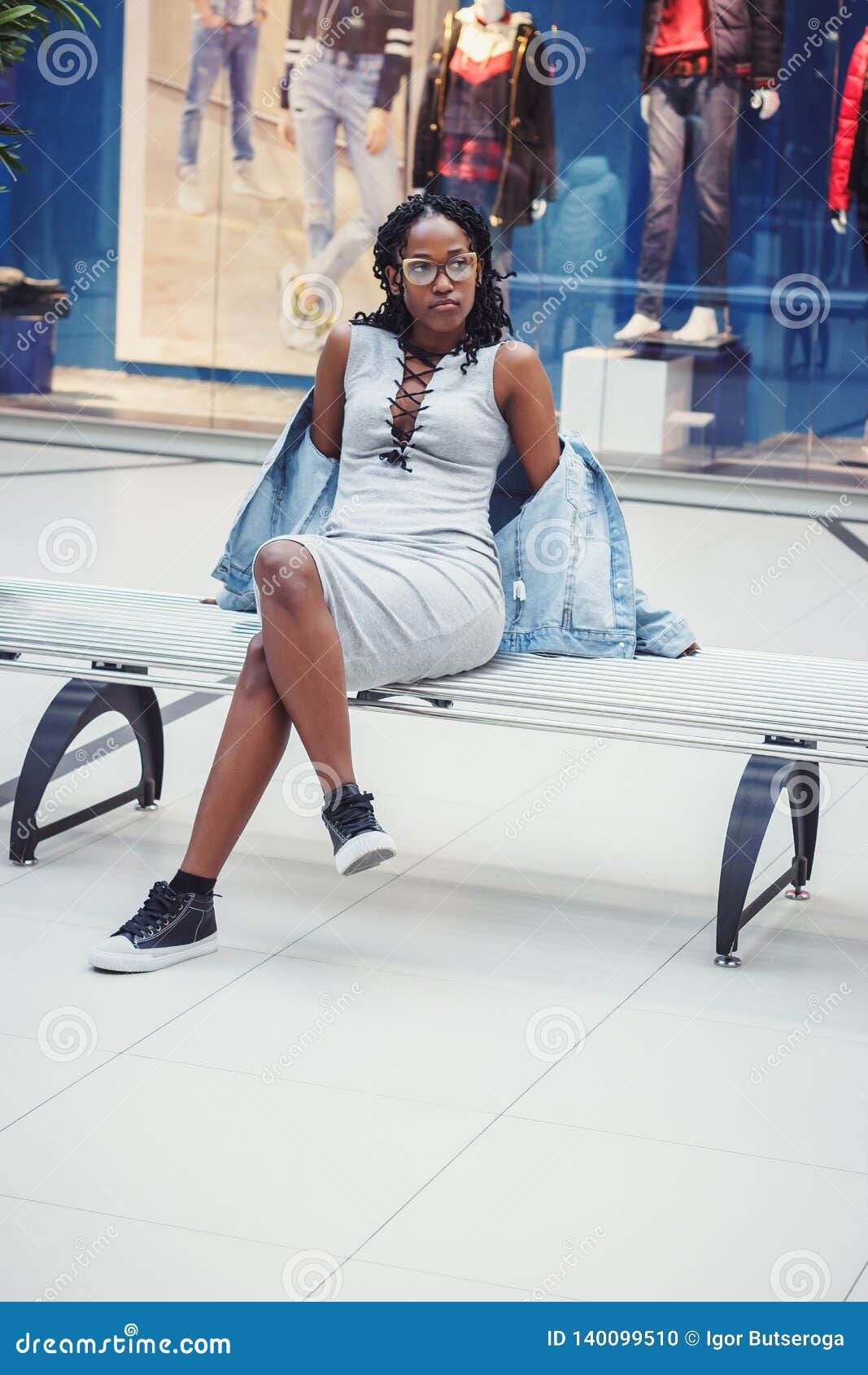 Young Dark Skinned Woman Dressed In Casual Clothes On The Bench In The