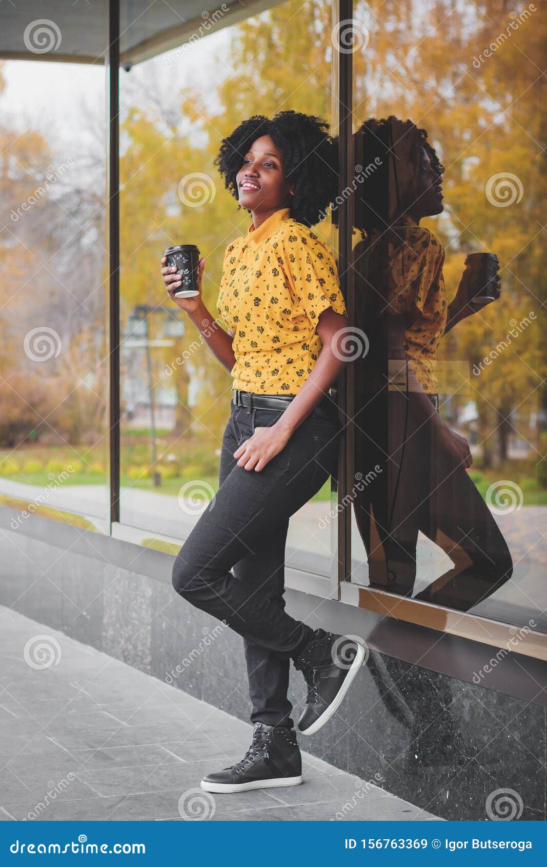 Young Dark Skinned Woman Dressed In Casual Clothes Holding Cup Of Hot