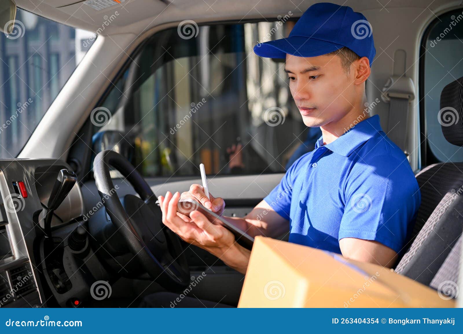 Young Delivery Man Checking Orders with Tablet before Handing Package ...