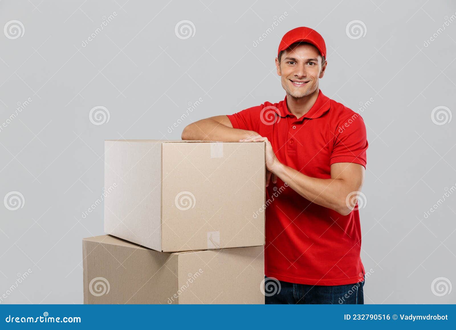 Young Delivery Man in Hat Smiling while Posing with Cardboard Boxes ...
