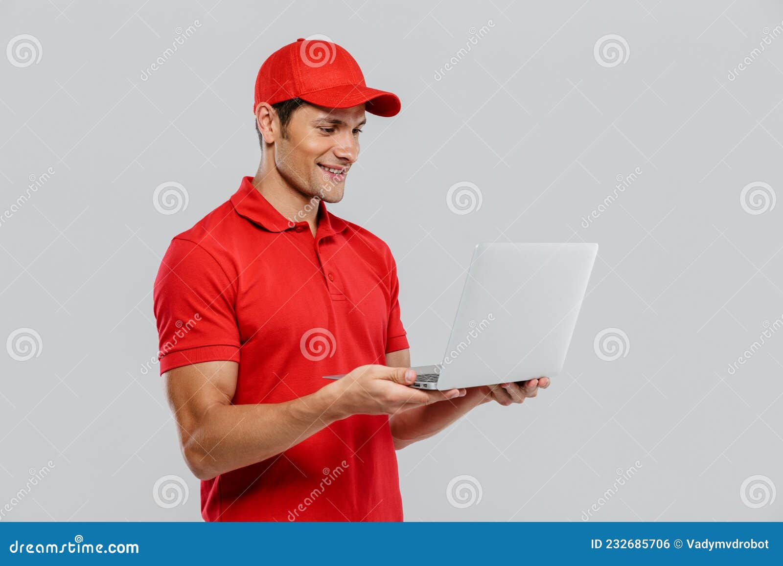 Young Delivery Man in Uniform Smiling while Posing with Laptop Stock ...