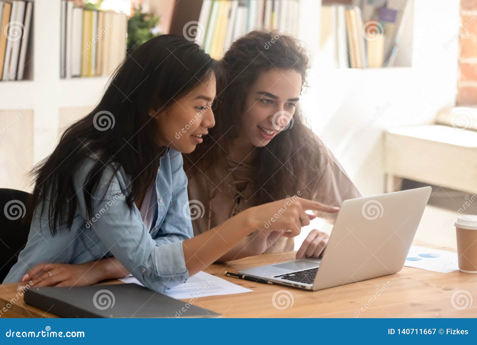 Young Diverse Students Workers Talking in Office Looking at Laptop ...