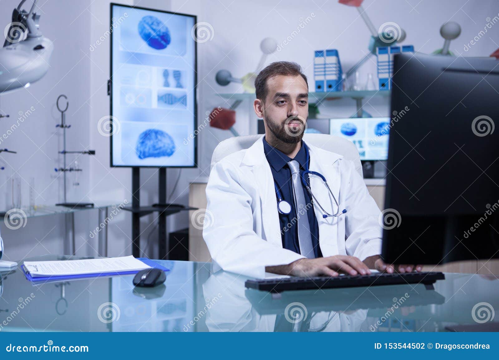 Young Doctor Siting at this Computer Typing a Recipe for a Patient ...
