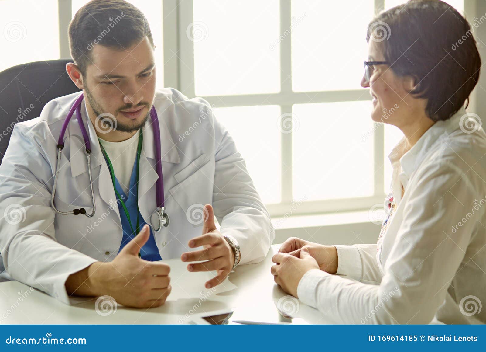 Young Doctor Talking To a Patient in the Office Stock Image - Image of ...