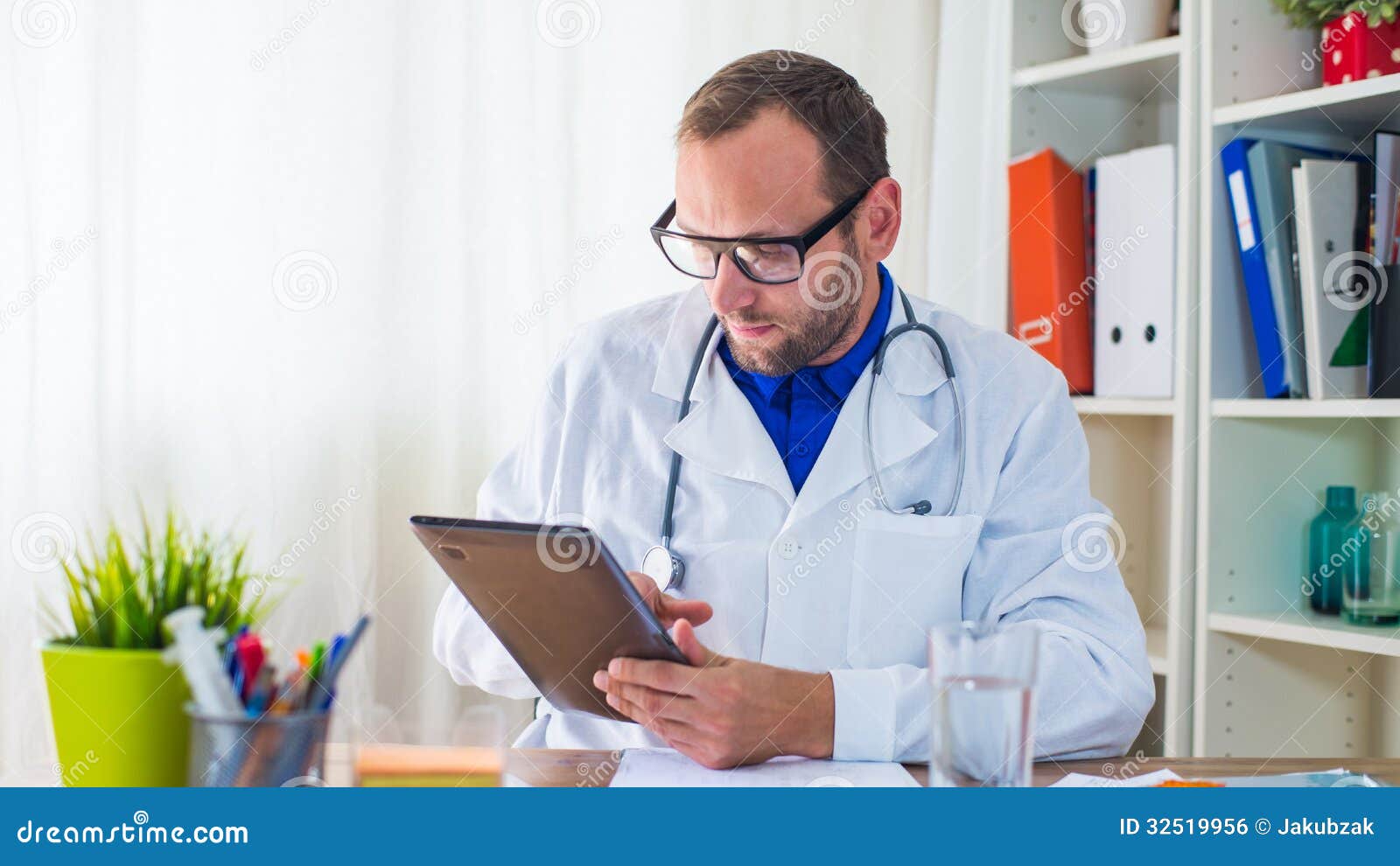 Young Doctor Using Tablet in His Surgery. Stock Photo - Image of ...